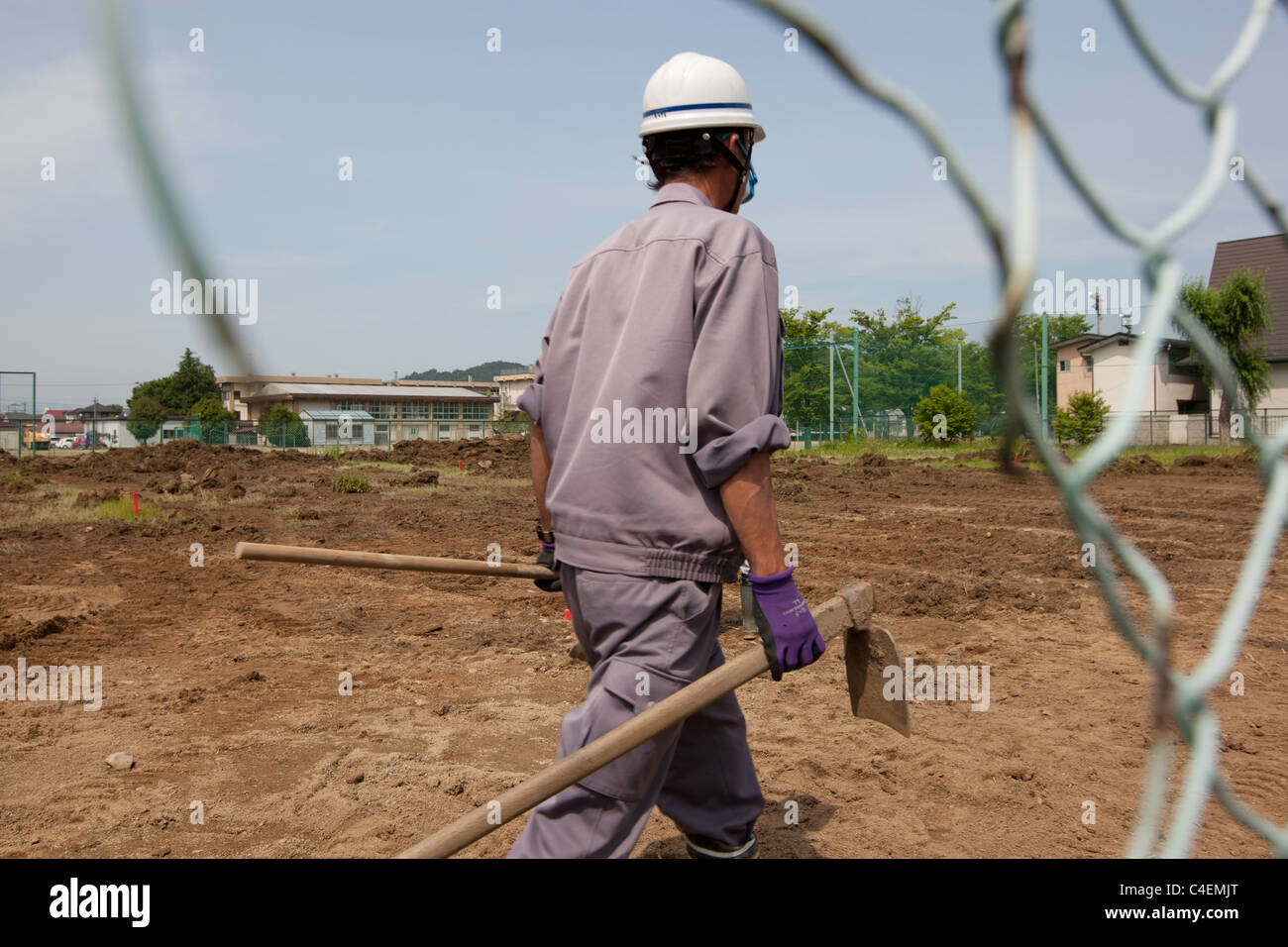 Workers remove top soil, contaminated by nuclear radiation, at school ...
