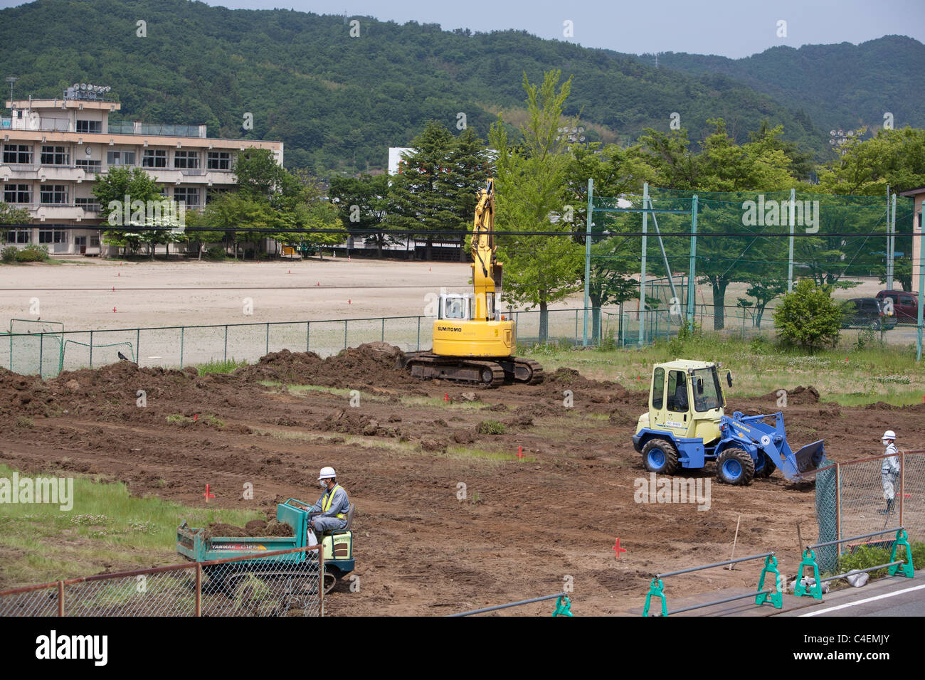 Workers remove top soil, contaminated by nuclear radiation, at school ...