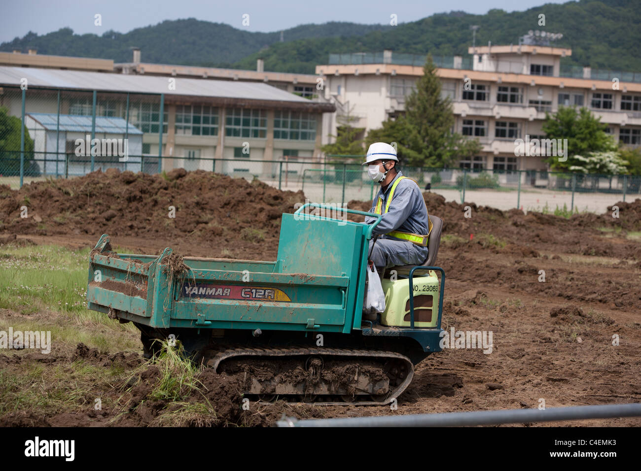 Workers remove top soil, contaminated by nuclear radiation, at school ...