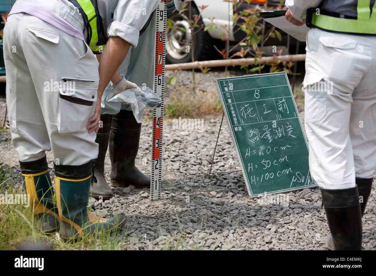 Workers undertake radiation contamination monitoring in the grounds of ...