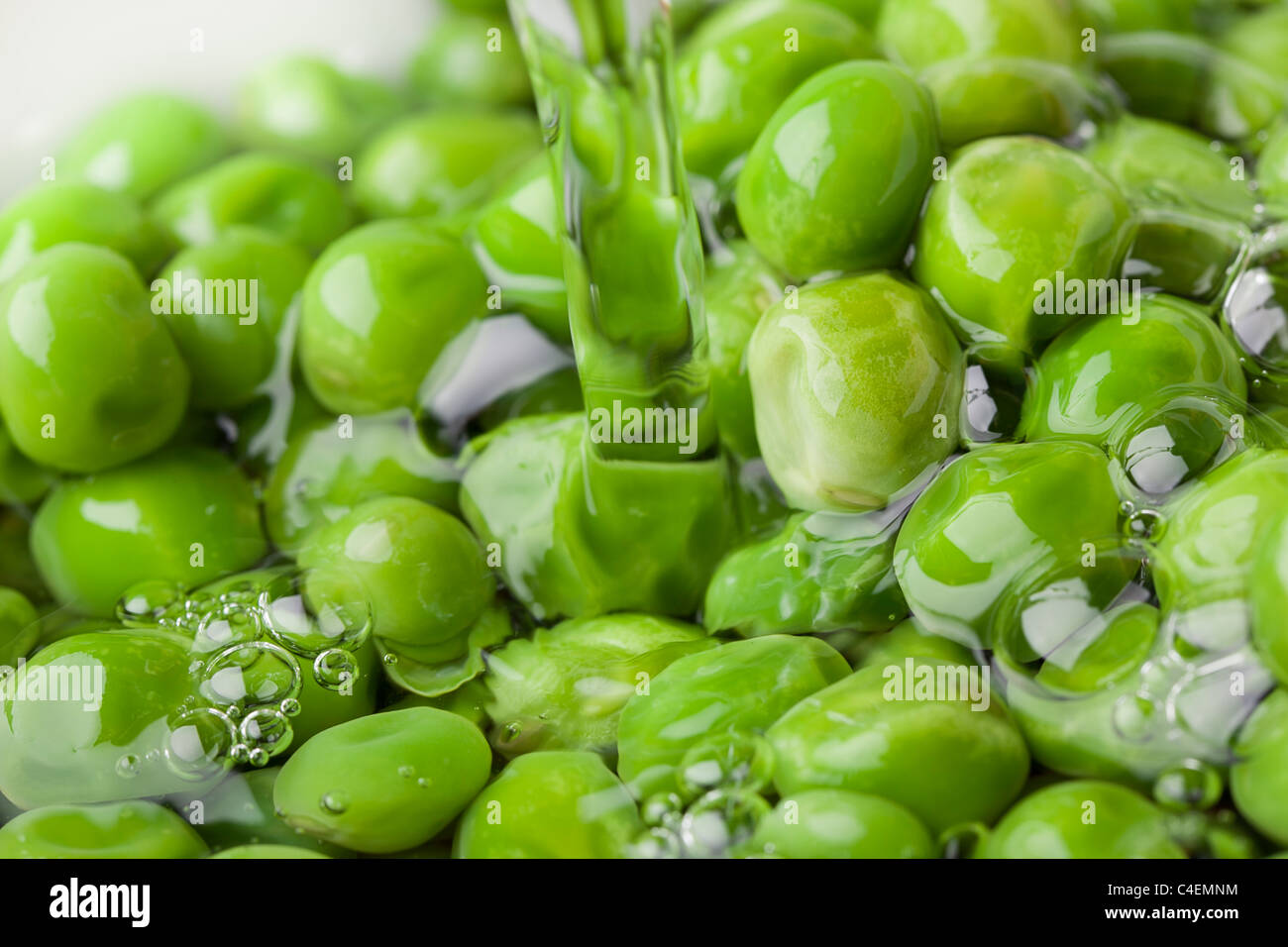 Fresh green peas being washed with water Stock Photo - Alamy
