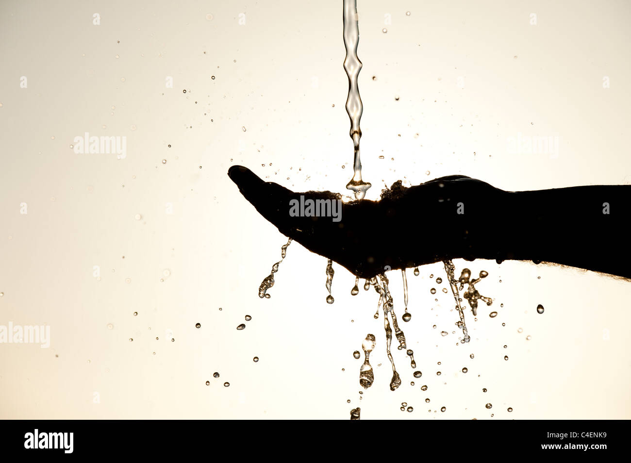 Water pouring and splashing on a hand. Silhouette Stock Photo - Alamy