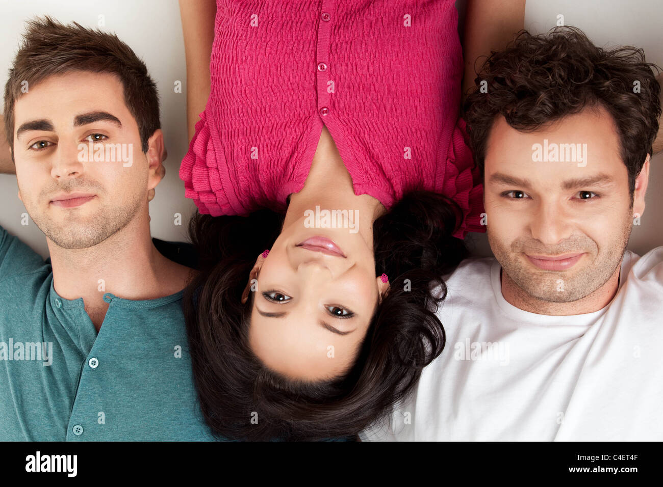 smiling woman laying on shoulders of two young guys Stock Photo - Alamy