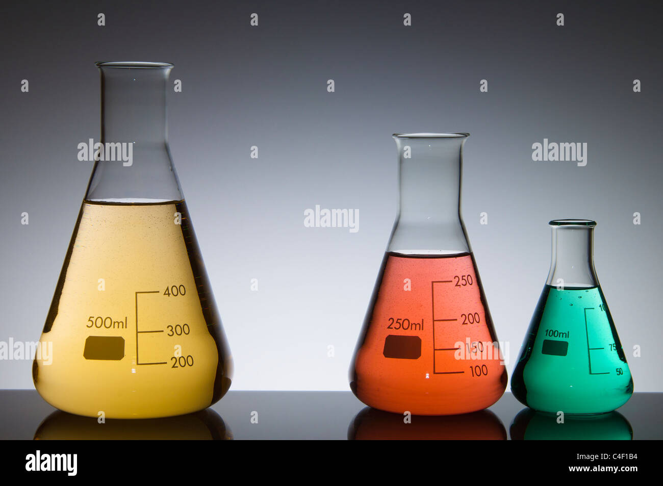 three conical flasks with liquid and white background Stock Photo - Alamy