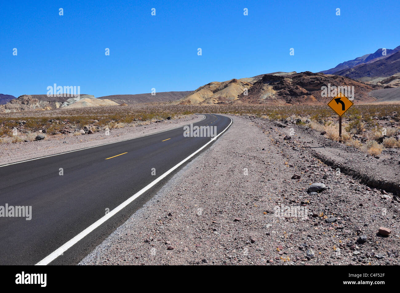 A big stretch of road, with a left turn, in the Mojave Desert ...