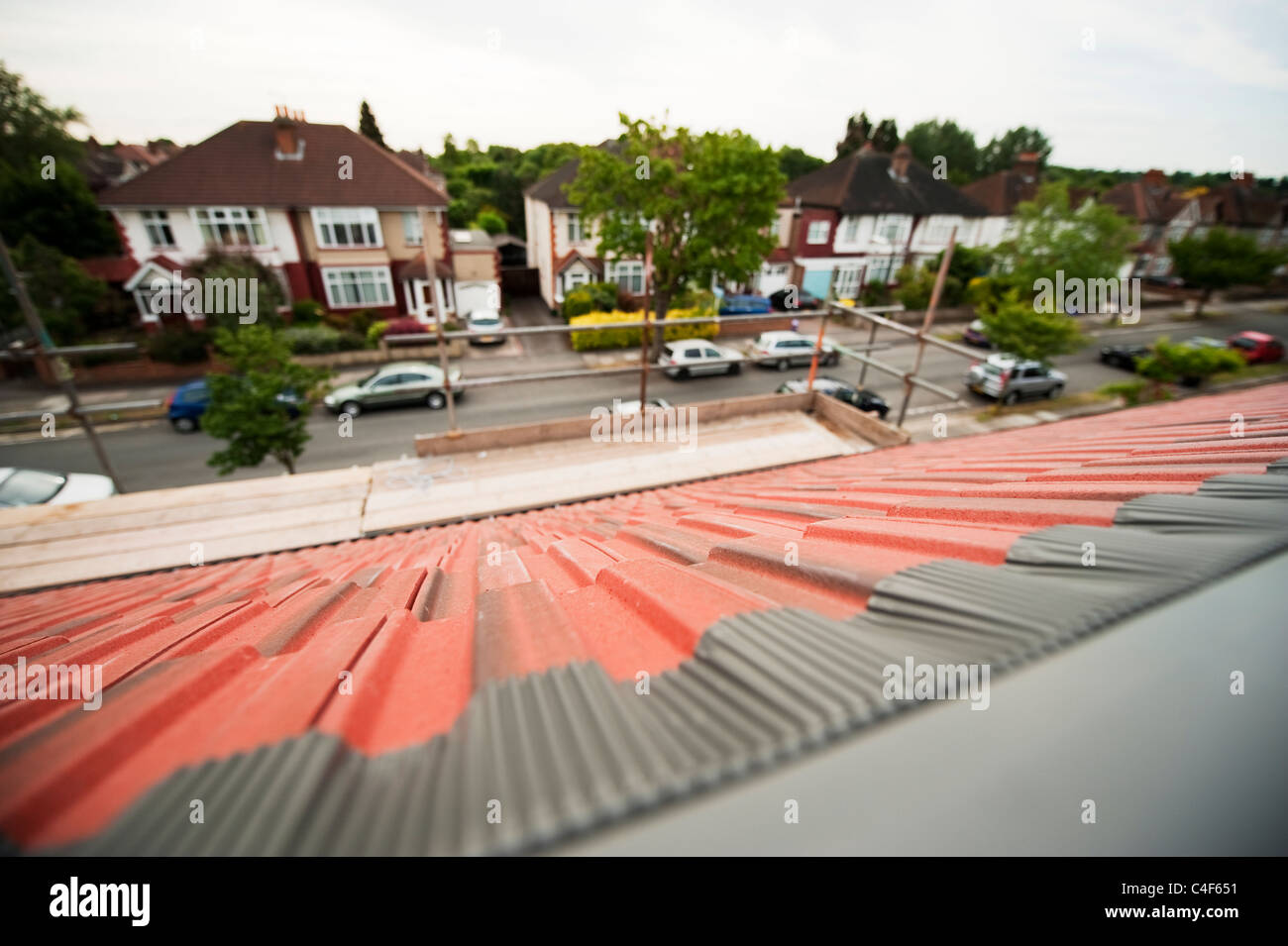 View out of roof window to newly tiled pitched roof in suburban street ...