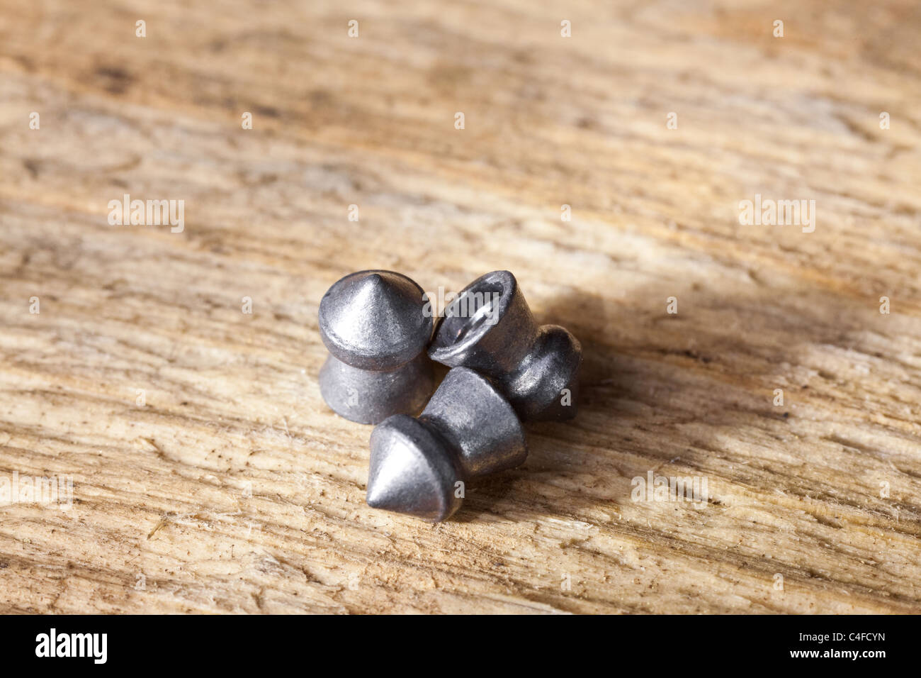 3 air gun bullets on unfinished wood Stock Photo - Alamy