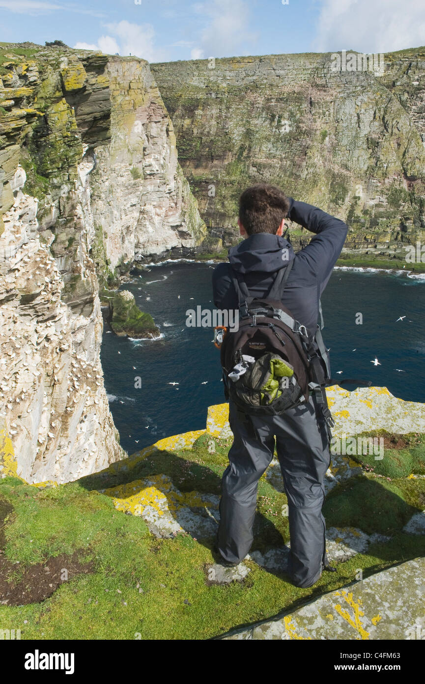 Photographer Eric Guth photographing Gannet colony, Isle of Noss ...
