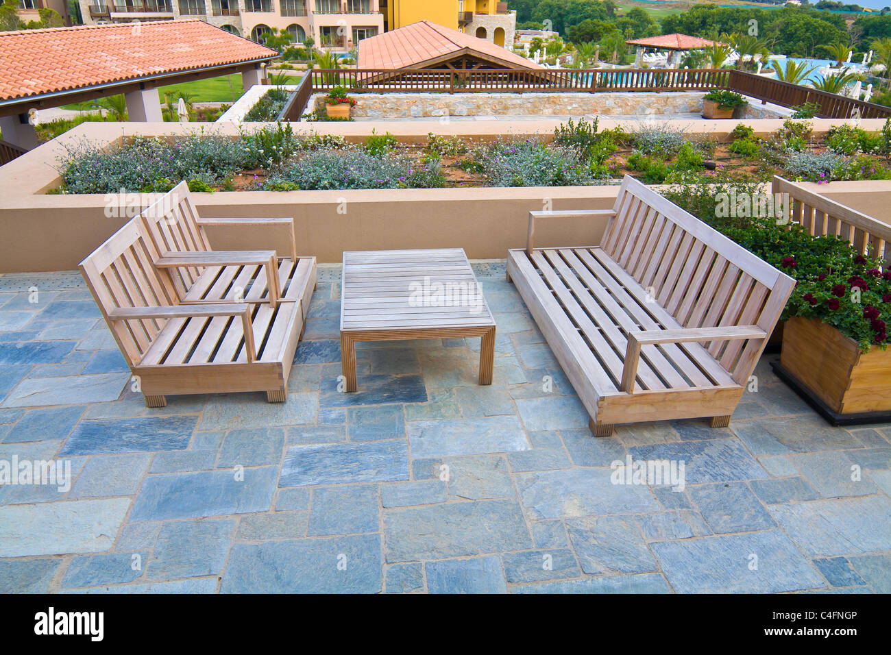 Wooden table sofa and chairs at resort Stock Photo - Alamy