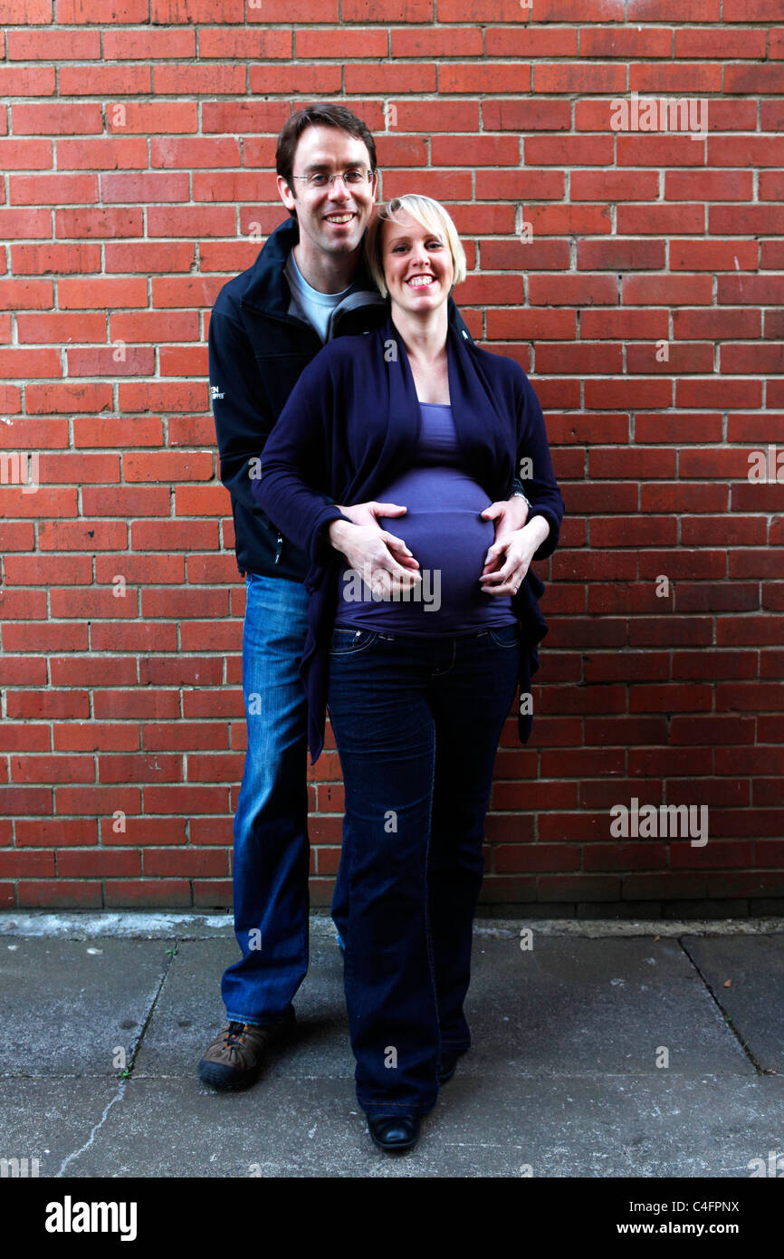 A couple of expectant parents stand together during the seventh month ...