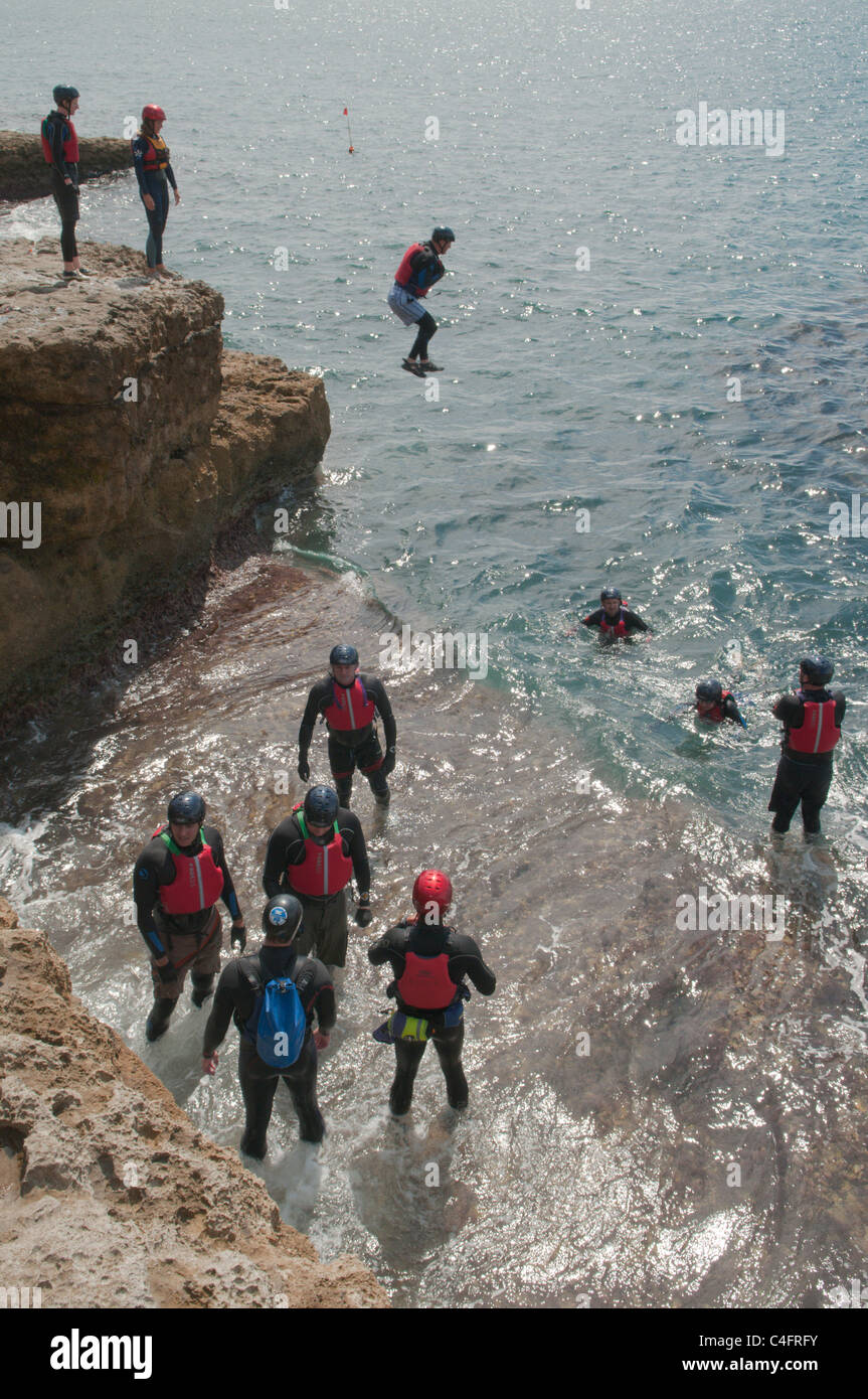Dancing Ledge, Swanage, Dorset, UK. July. Coasteering. Group working ...