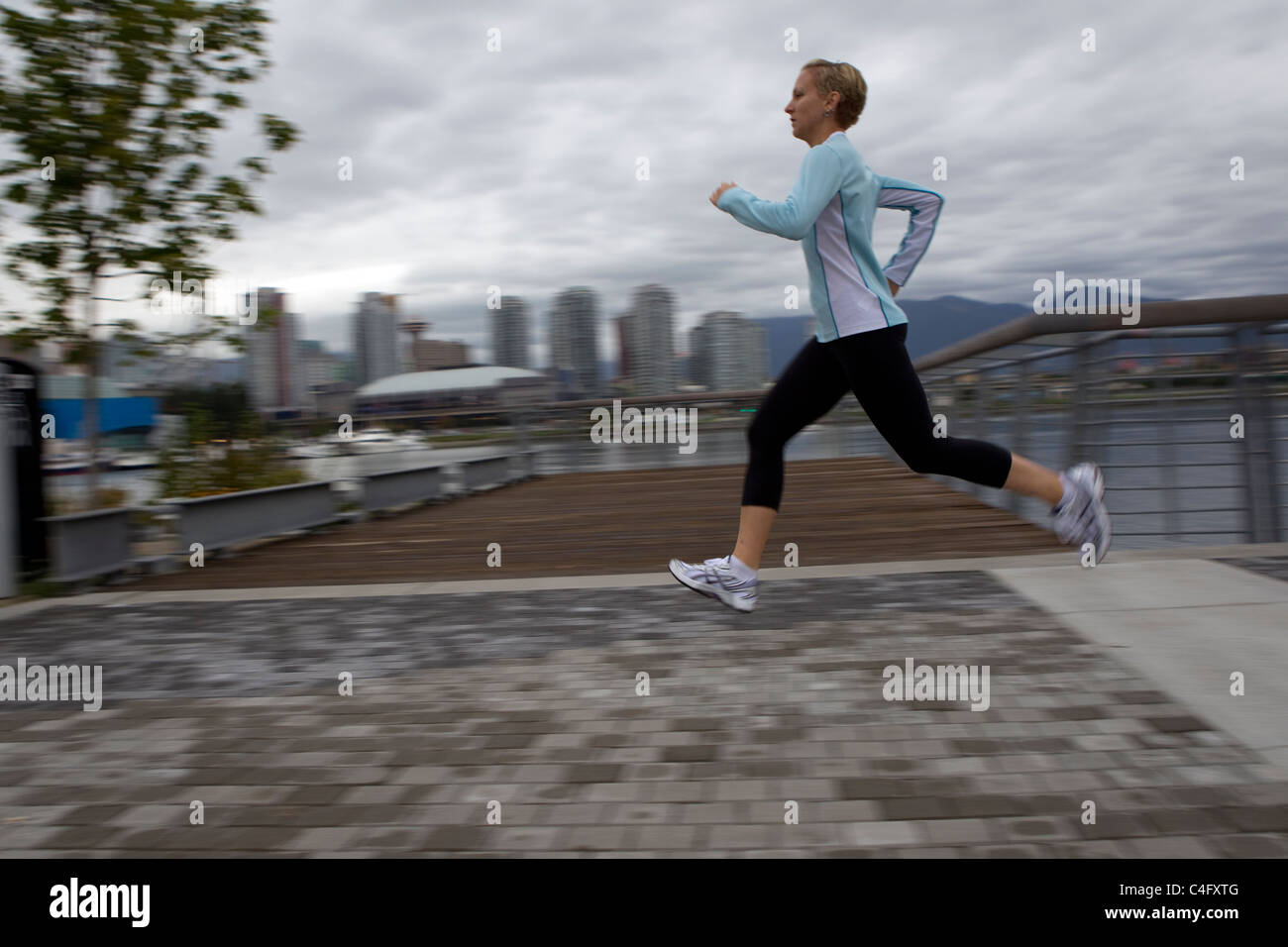 Ultra marathon female runner running in the city of Vancouver BC Canada ...