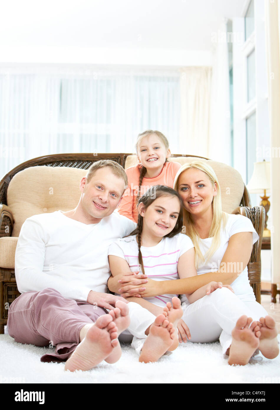 Portrait of happy family with two children sitting at home Stock Photo ...