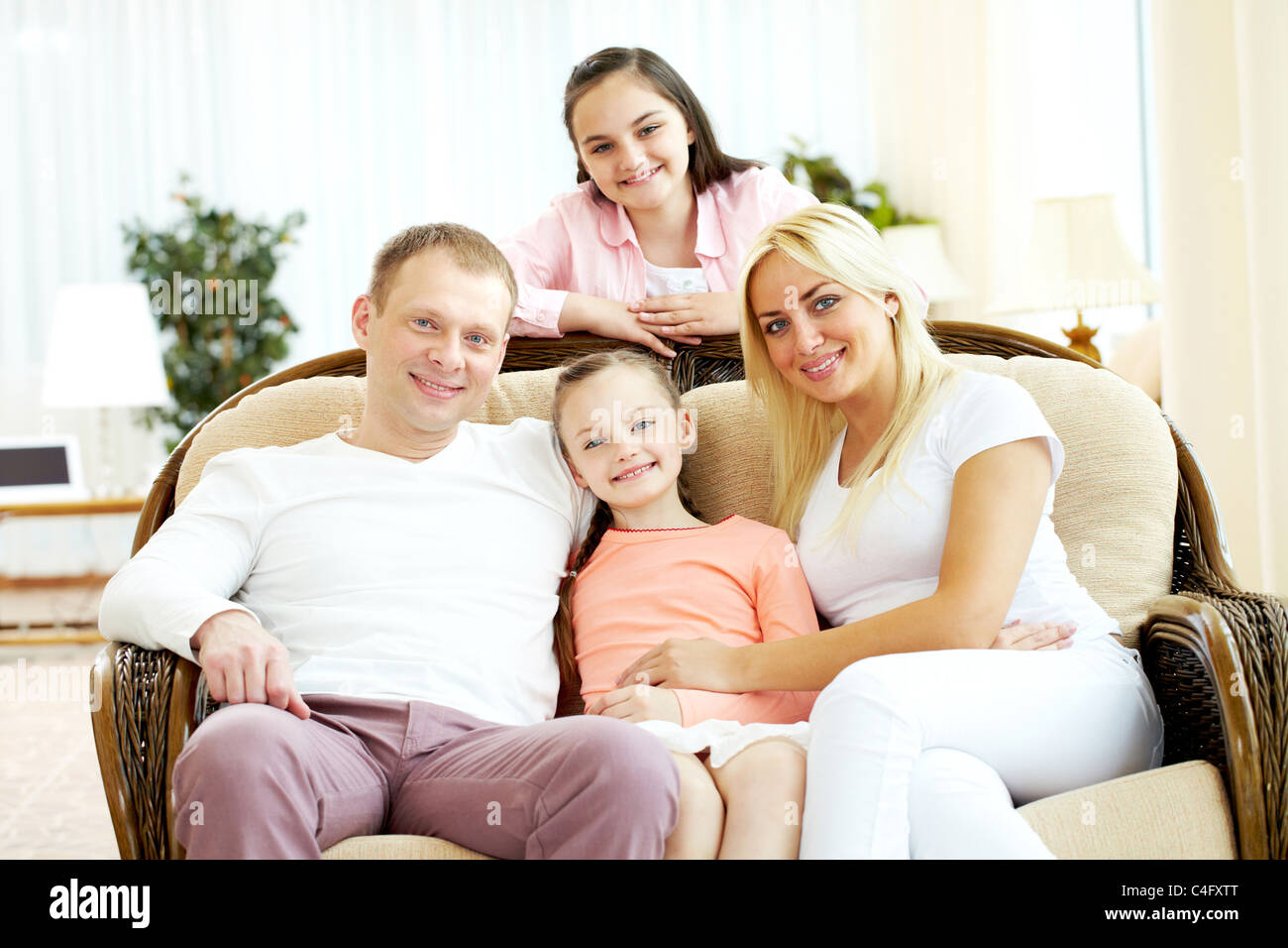 Portrait of happy family with two children sitting at home Stock Photo ...