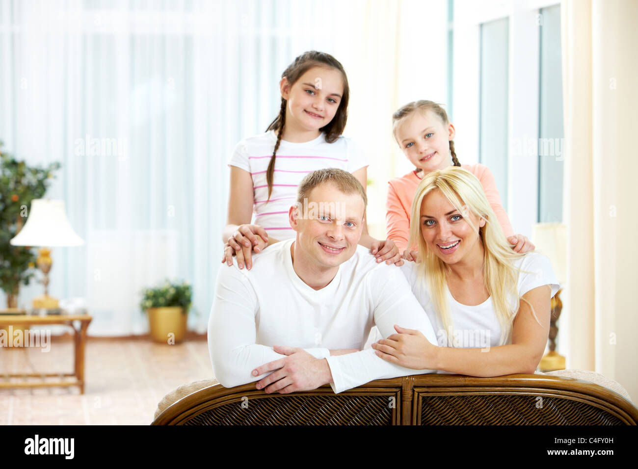 Portrait of happy couple with two children on background looking at ...