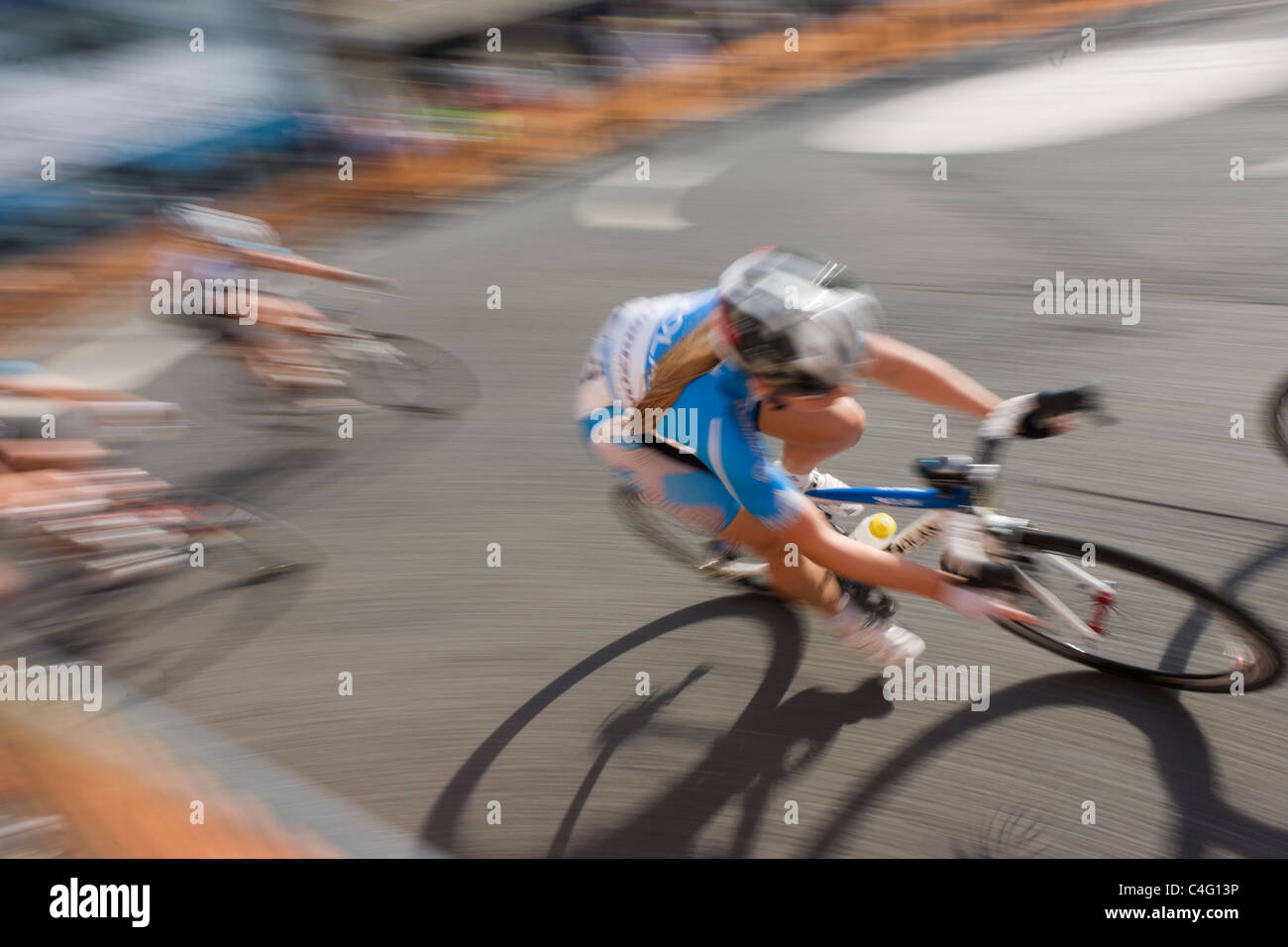 With bike shadows, blurred women cyclists turn into a corner of a ...
