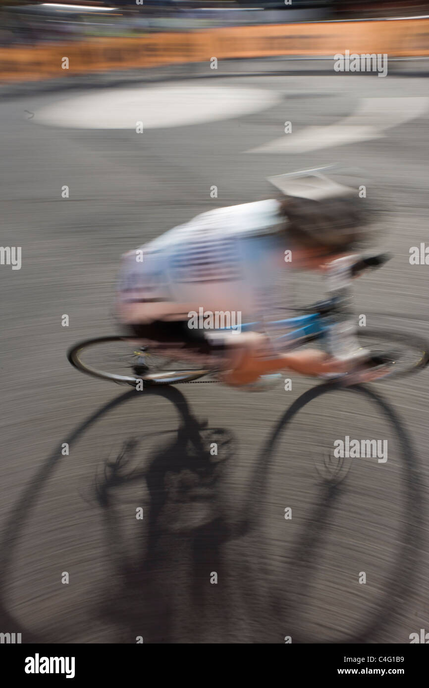 With bike shadows, blurred women cyclists turn into a corner of a ...