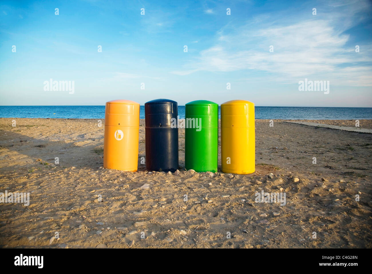 four coloured garbage barrels at the beach of mazarron murcia spain ...