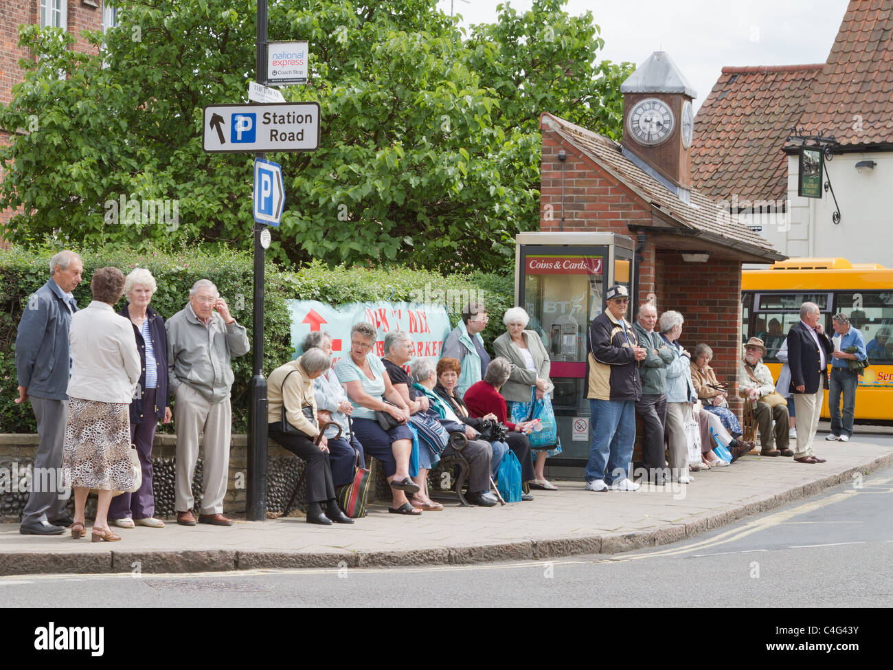 Group of people at a bus stop in Holt, Norfolk Stock Photo - Alamy