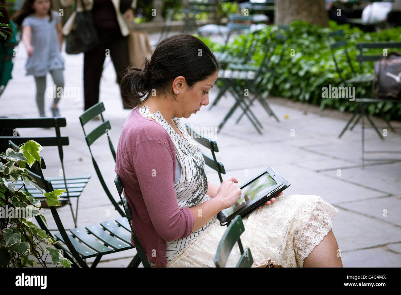 An Apple iPad user with her tablet computer in Bryant Park in New York ...
