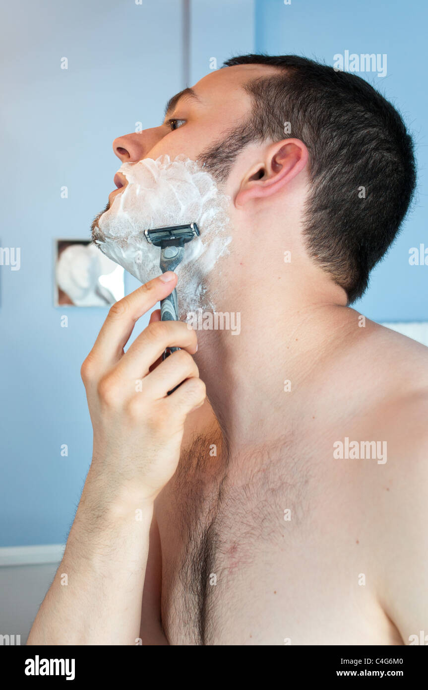 Young man shaving his beard Stock Photo - Alamy Young man shaving his beard Stock Photo - Alamy