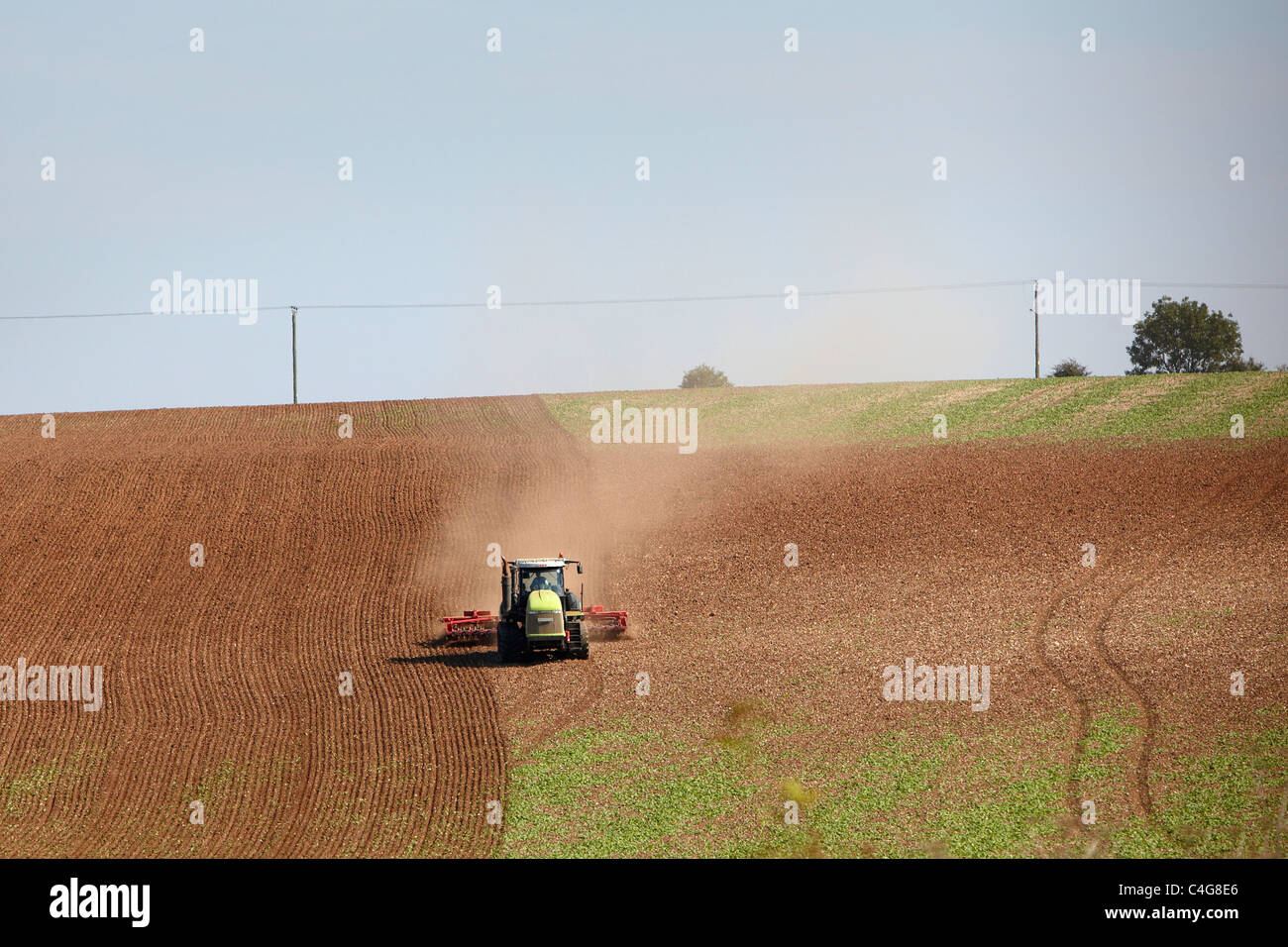Farmer on a tractor farming and plowing in a field Stock Photo - Alamy