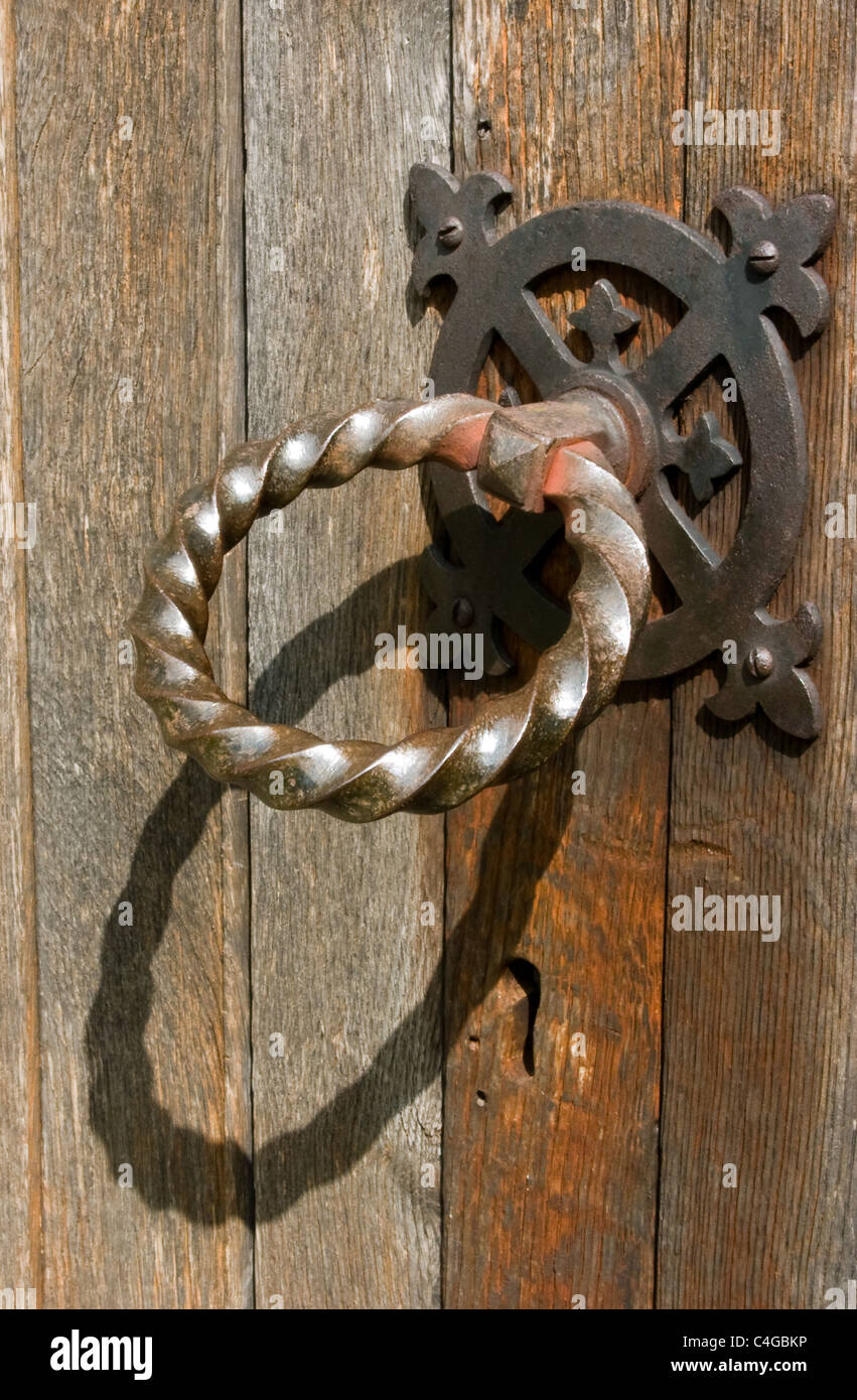 Wrought iron handle and shadow on an old wooden door Stock Photo - Alamy
