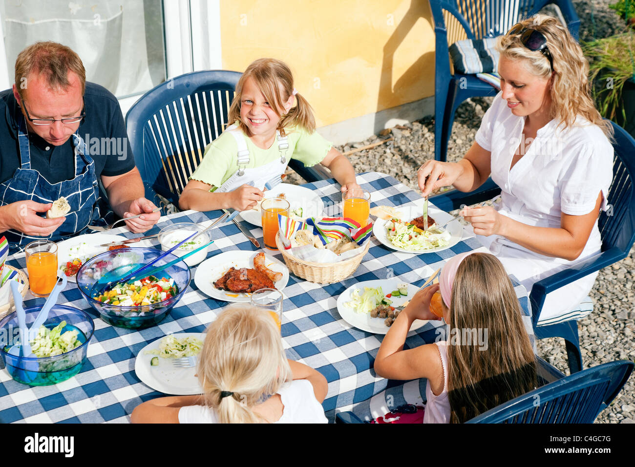 Family having a barbecue in the garden, eating Stock Photo - Alamy