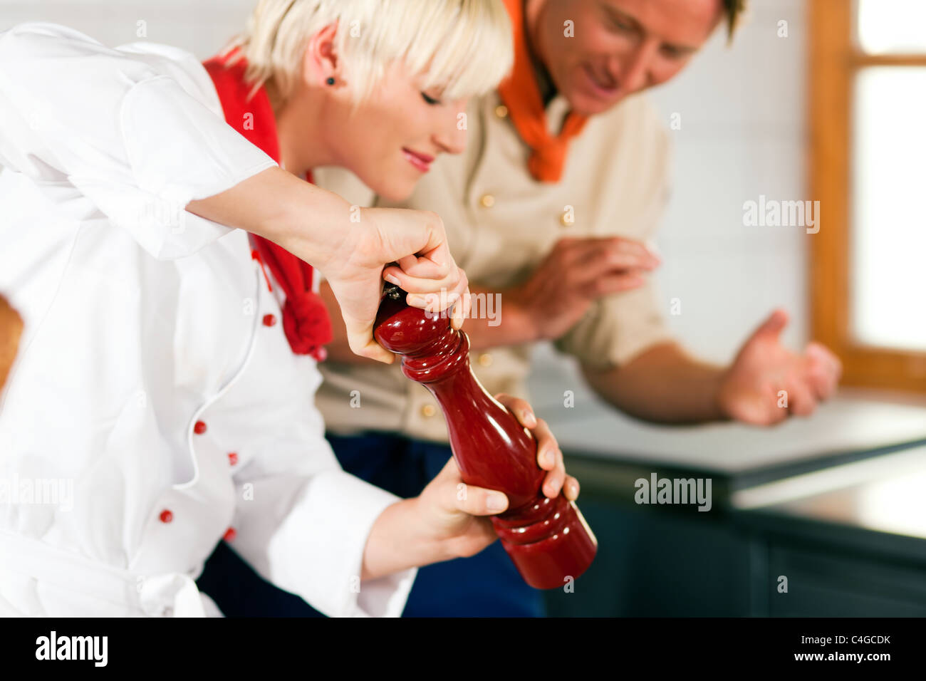 Two chefs in teamwork - man and woman - in a restaurant or hotel ...