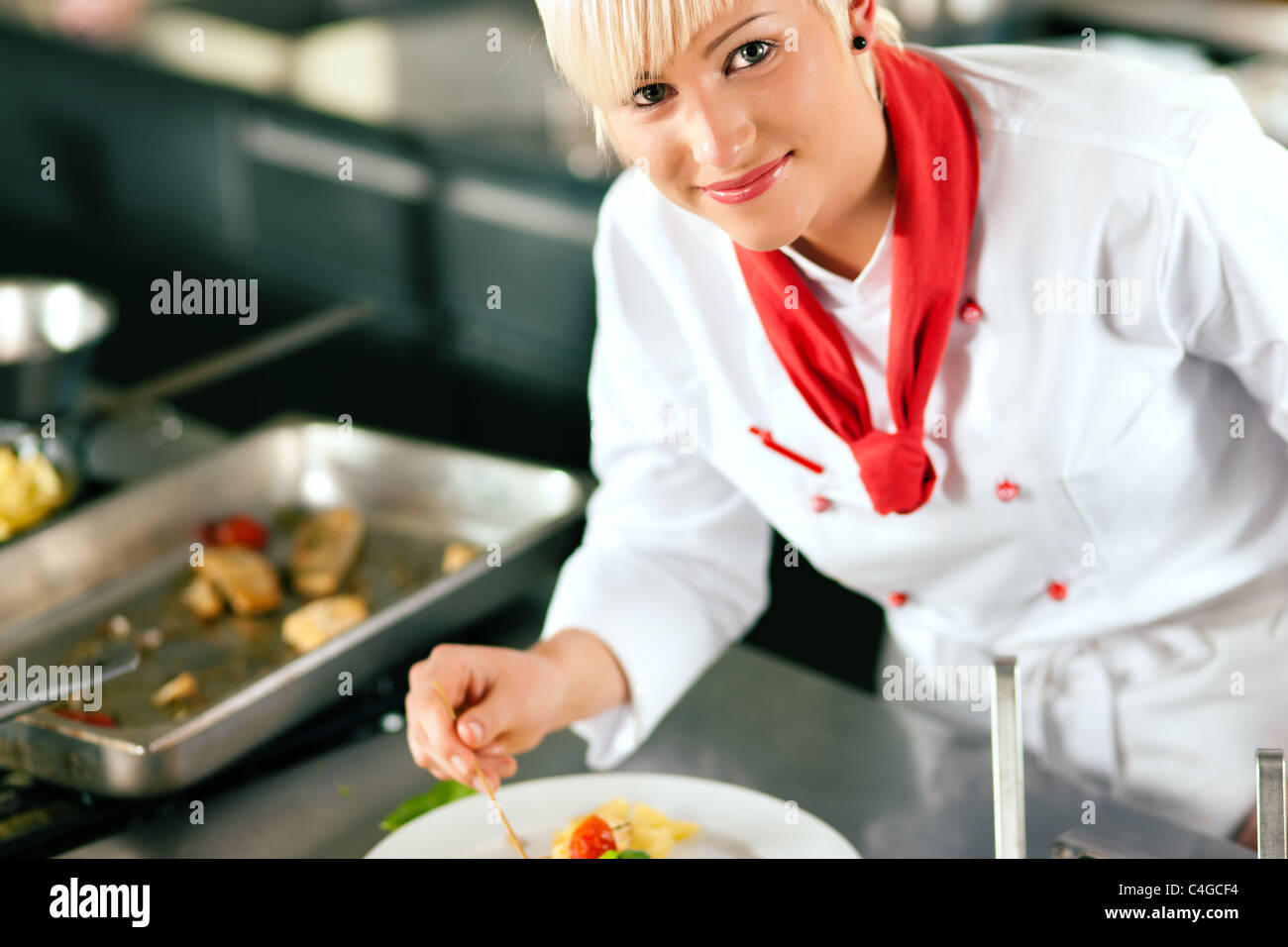 Female Chef in a restaurant or hotel kitchen cooking delicious food ...