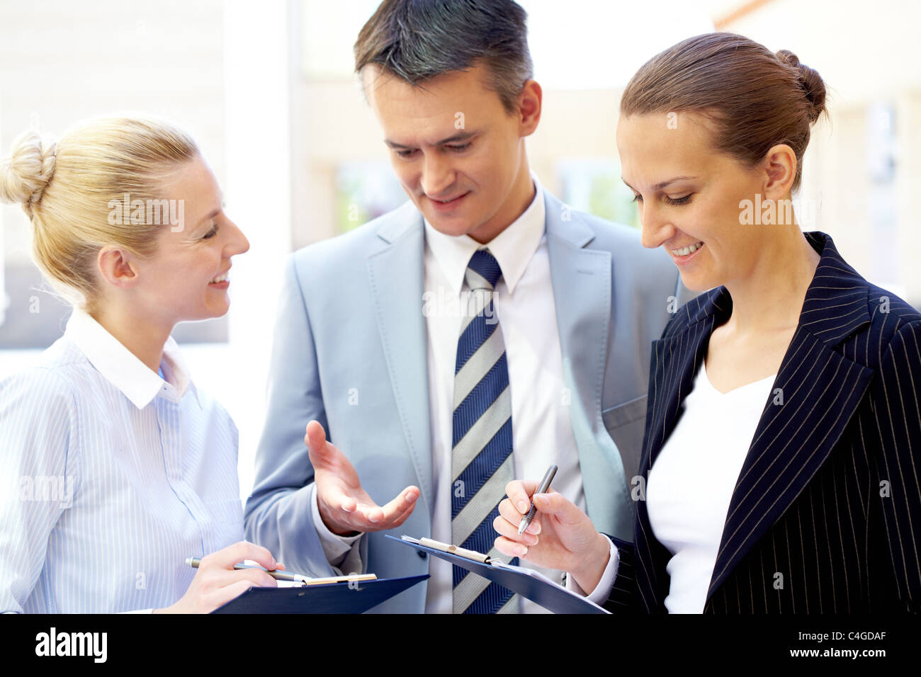 Portrait of busy people discussing new project or working plan outdoors ...