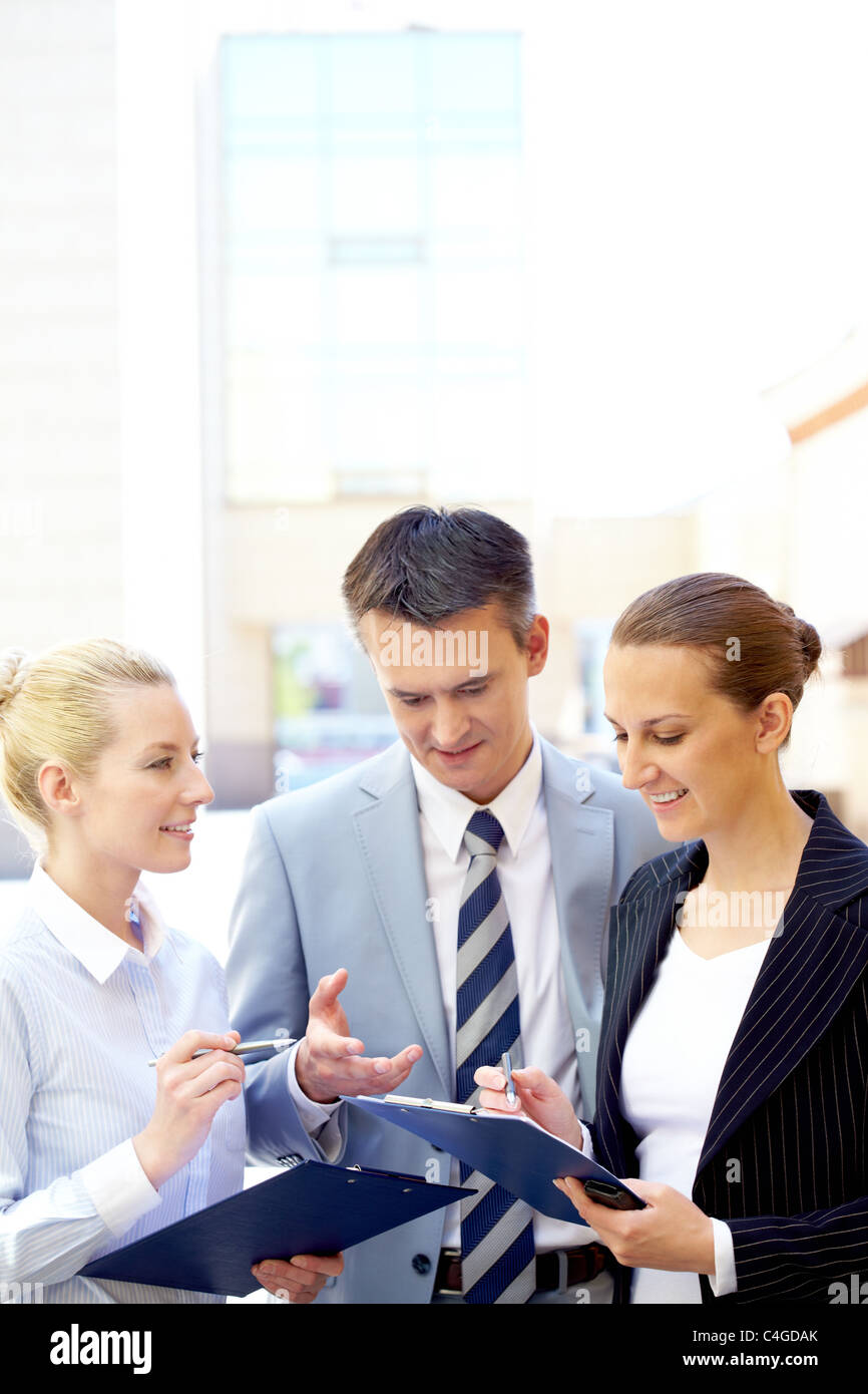 Portrait of busy people discussing new project or working plan outdoors ...