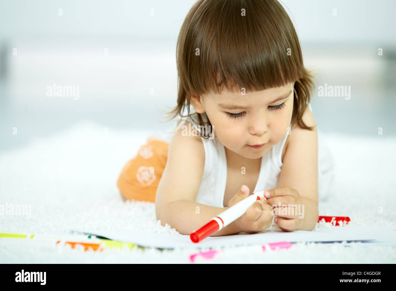 Portrait of cute girl holding highlighter at home Stock Photo - Alamy