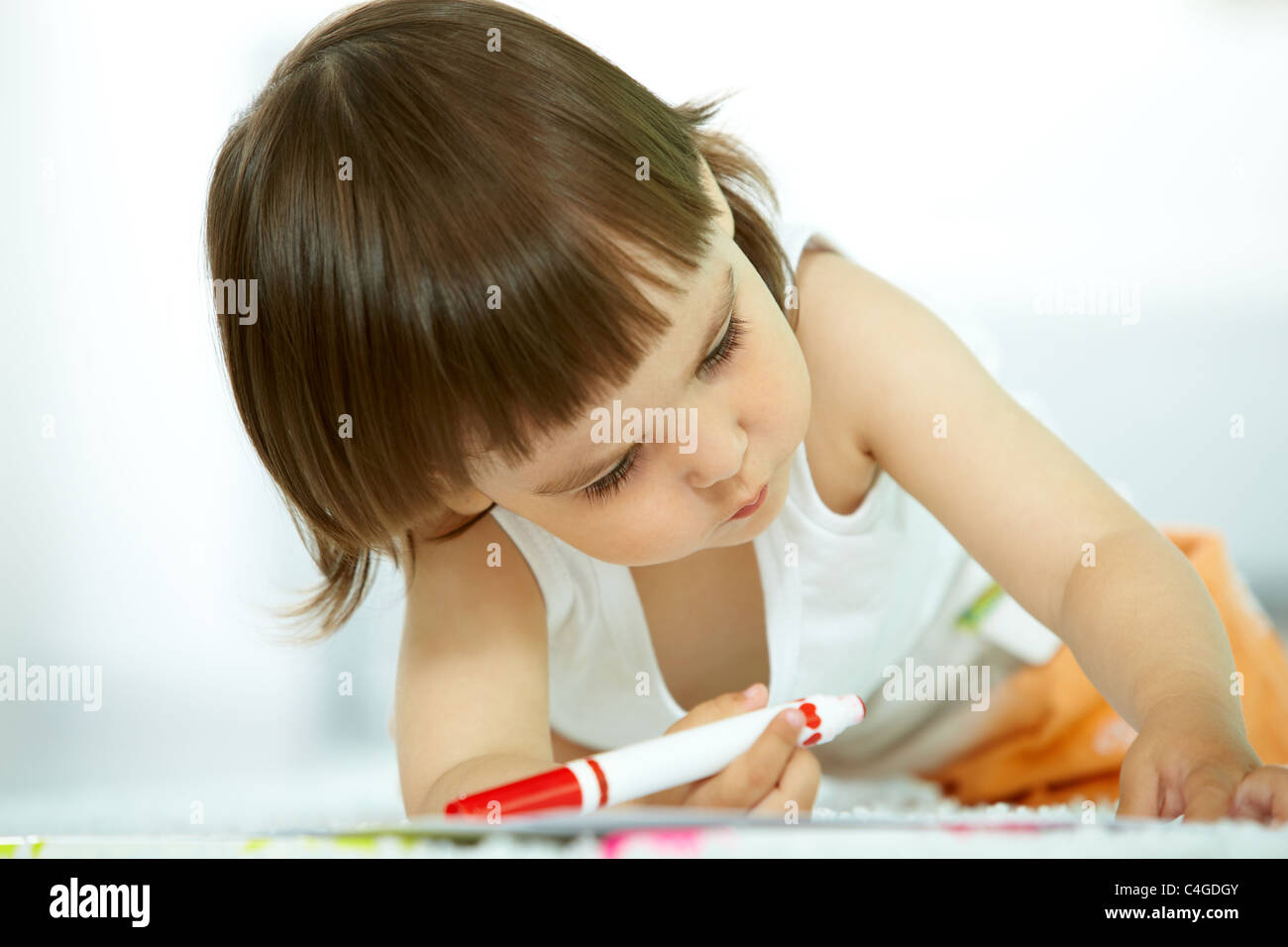 Portrait of cute girl holding highlighter and drawing Stock Photo - Alamy