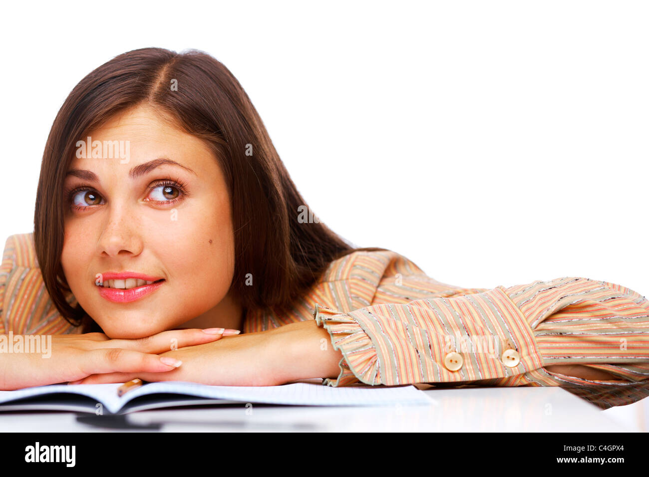 Beautiful female student smiling and looking away over white background ...