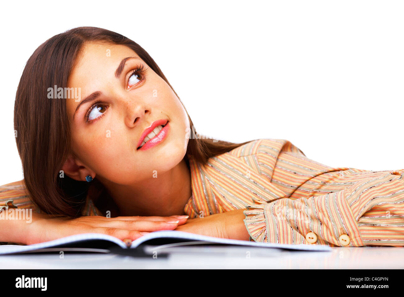 Beautiful female student smiling and looking away over white background ...