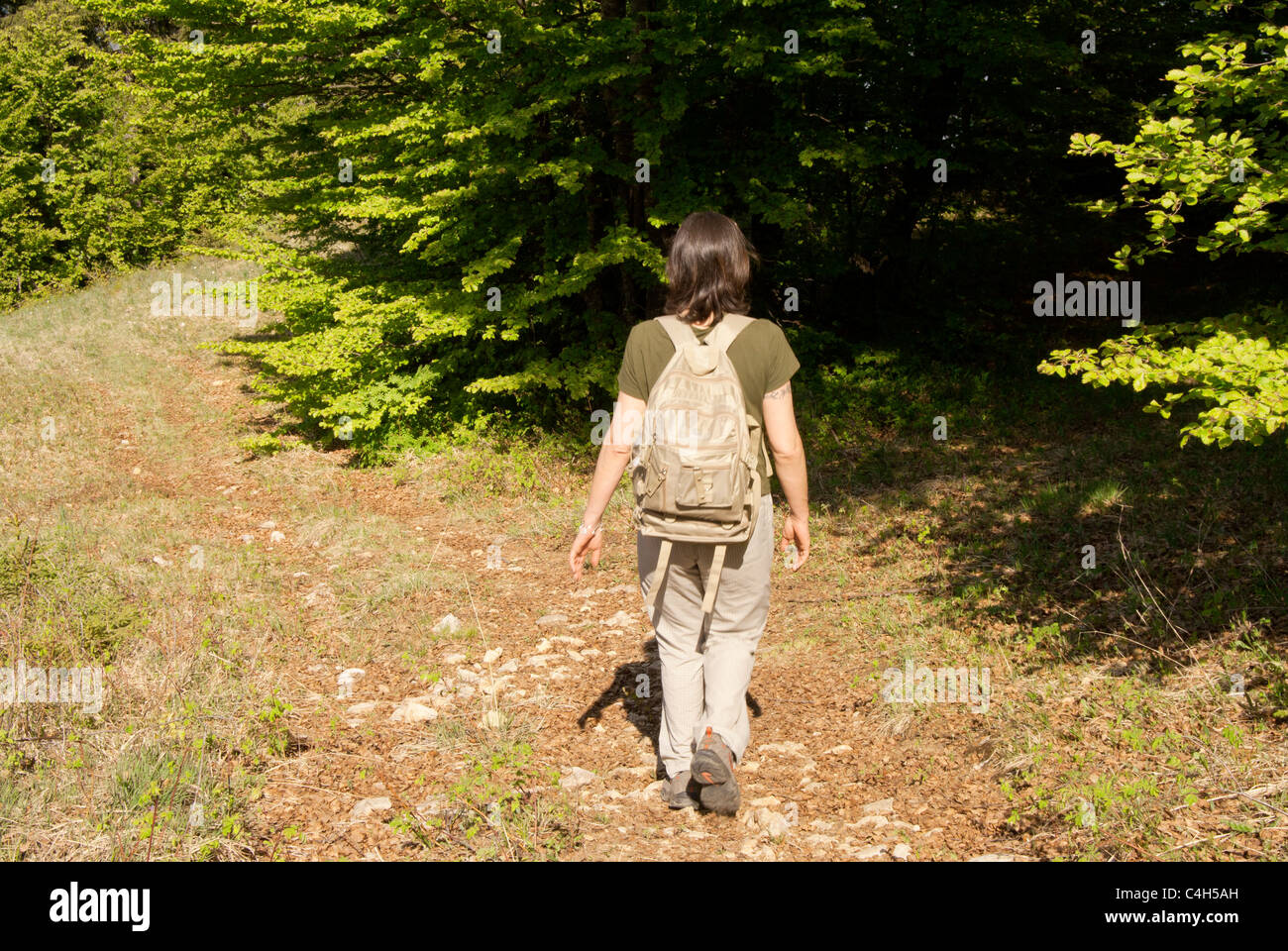 Girl walking along path on open grassy hillside Stock Photo - Alamy