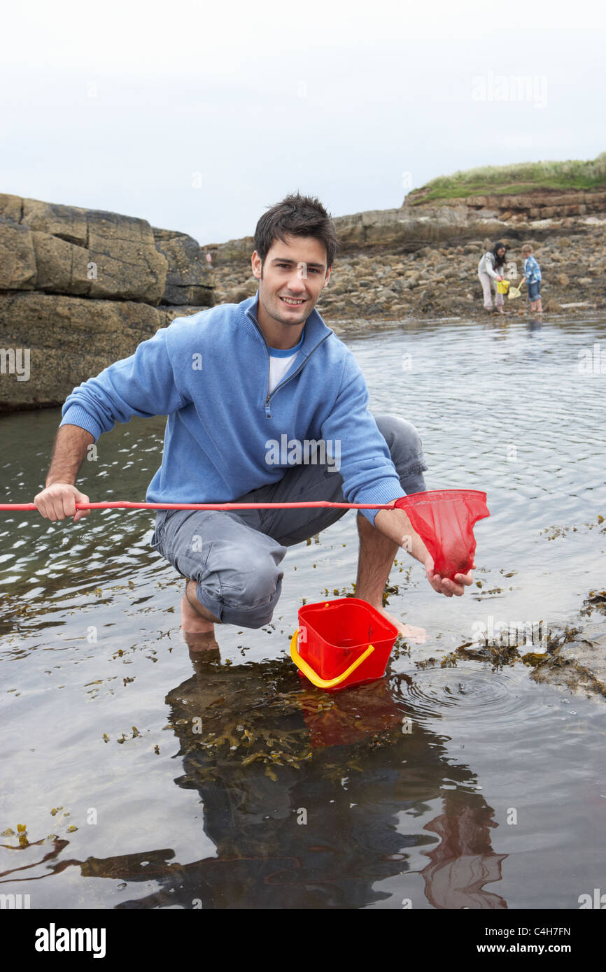 Young family at beach collecting shells Stock Photo - Alamy