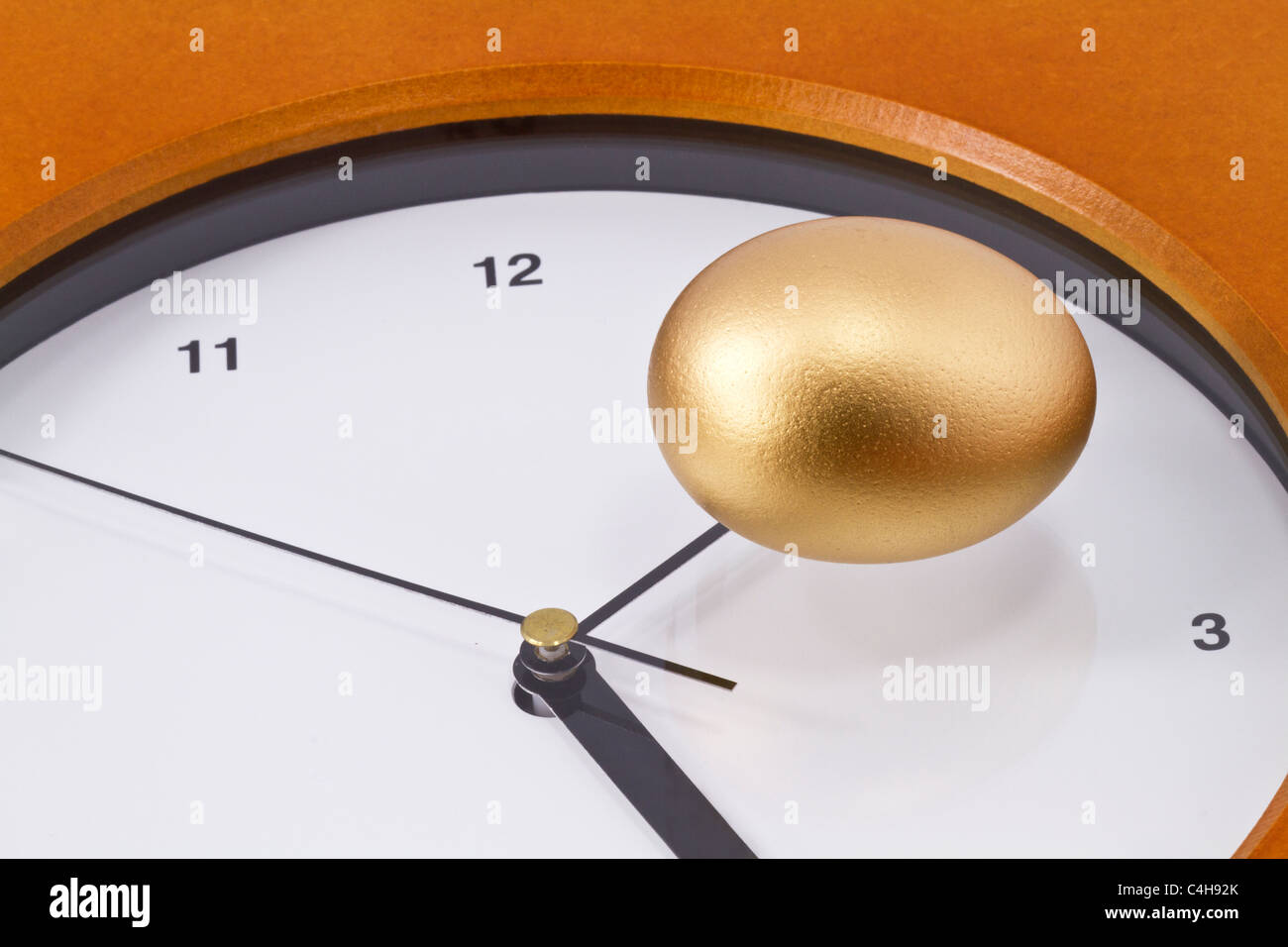 Gold nest eggs sits on ticking clock Stock Photo - Alamy