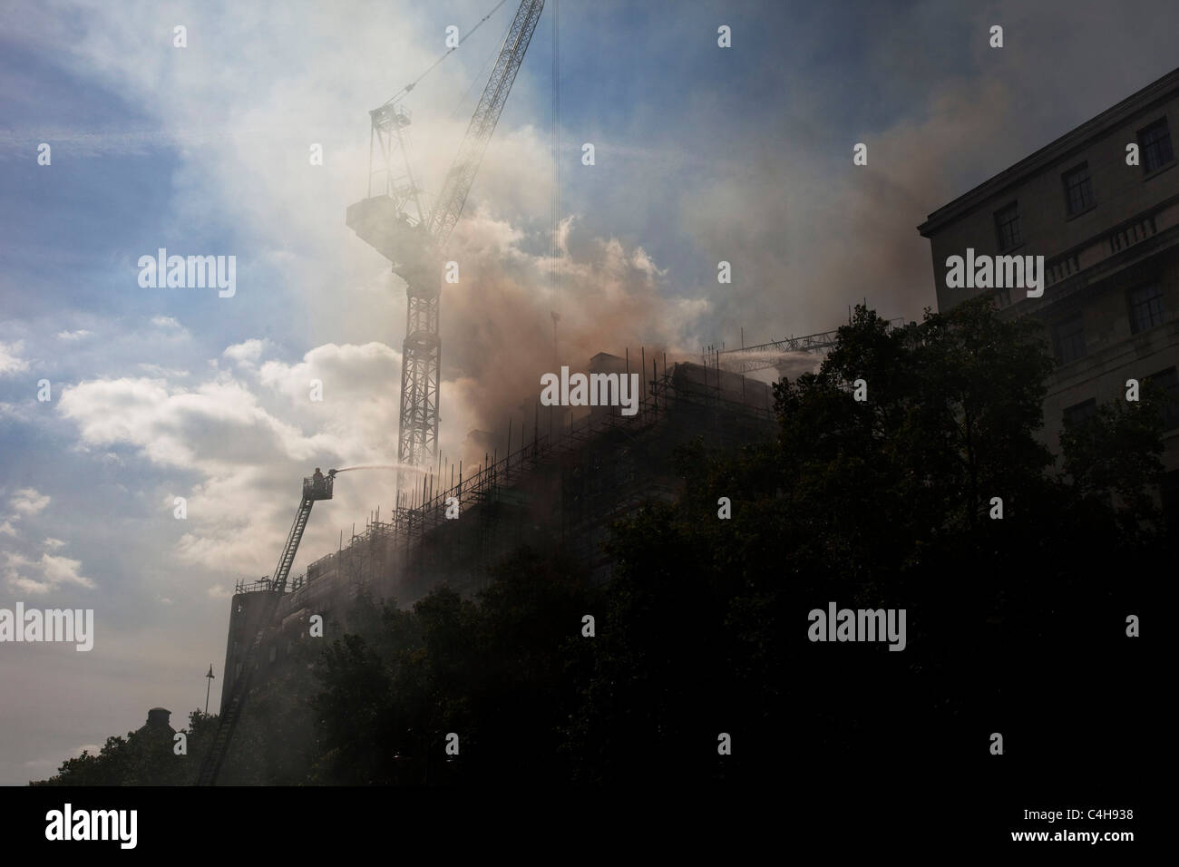 Fireman aims a jet of water at a large building on fire which was under ...