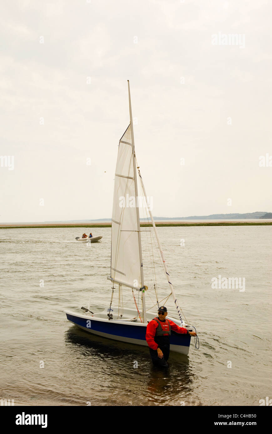 sailor dragging in small sailing boat for mooring Stock Photo - Alamy