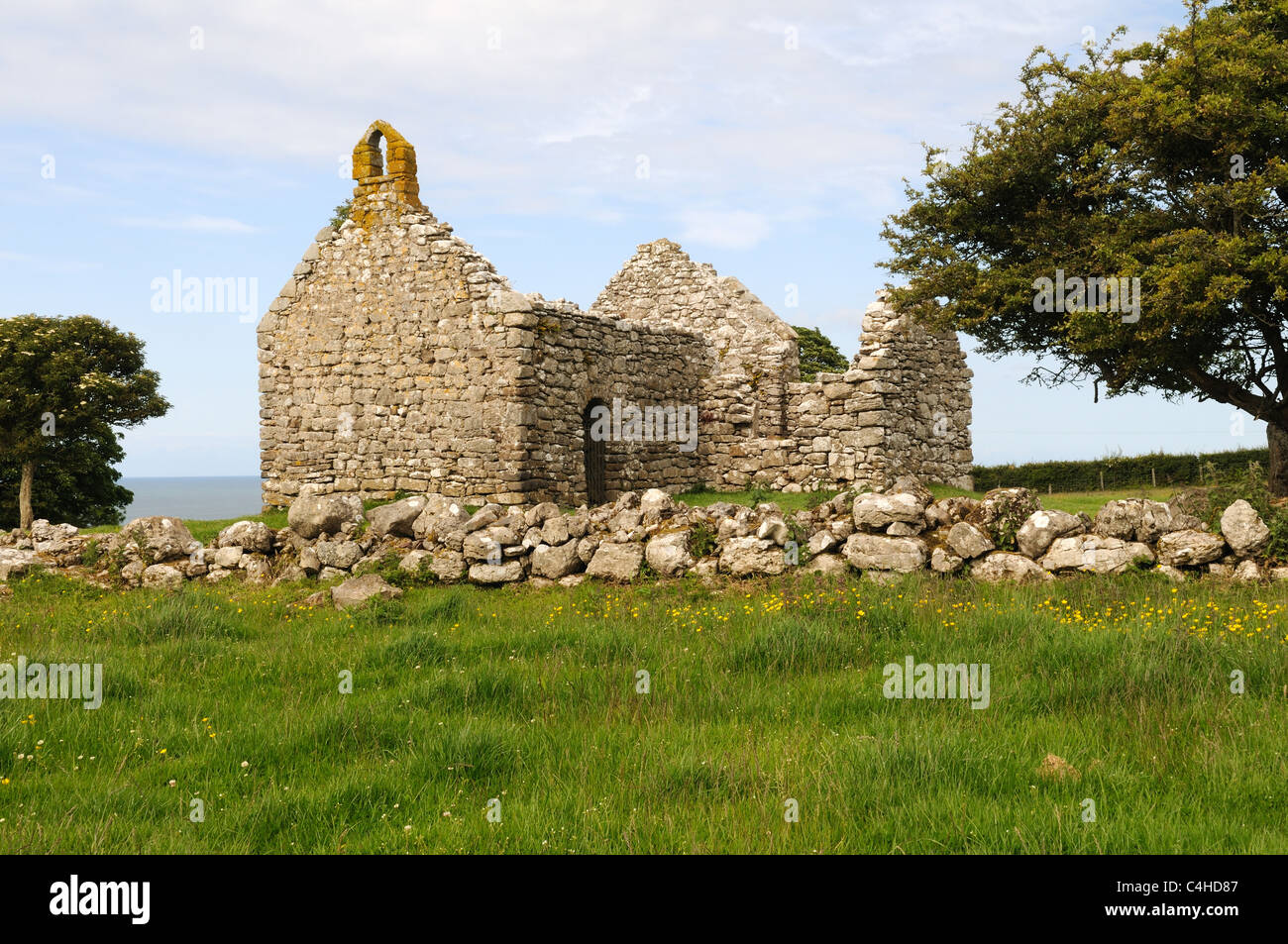 Remains of 12th century Lligwy Chapel overlooking Lligwy Bay Moelfre ...
