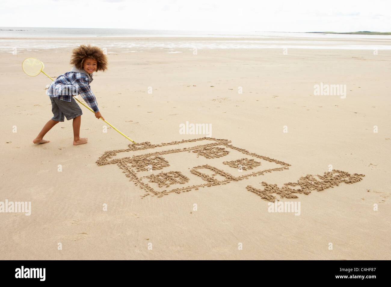 Boy drawing in sand Stock Photo - Alamy
