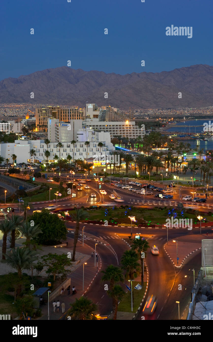 A vertical view of the hotel and beach area of Eilat at dusk with the ...