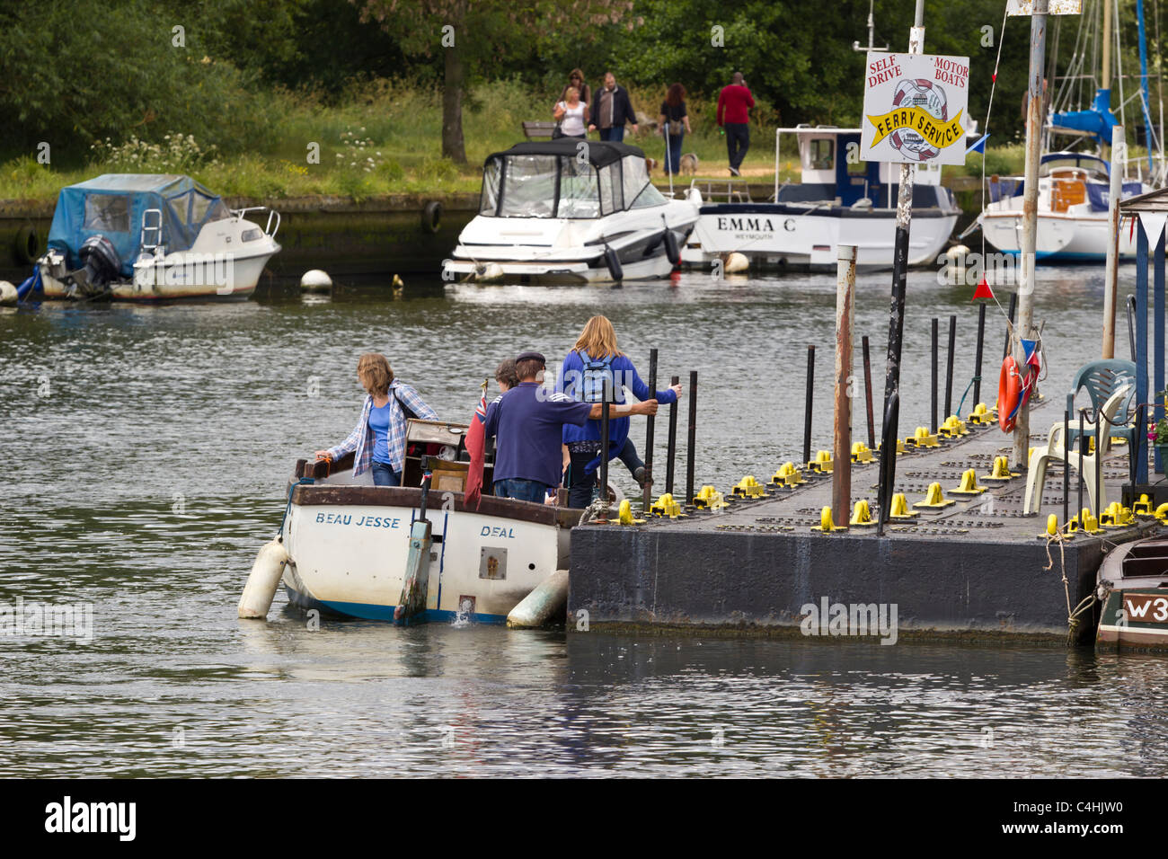 Passengers boarding Wick passenger small ferry on river Stour between ...