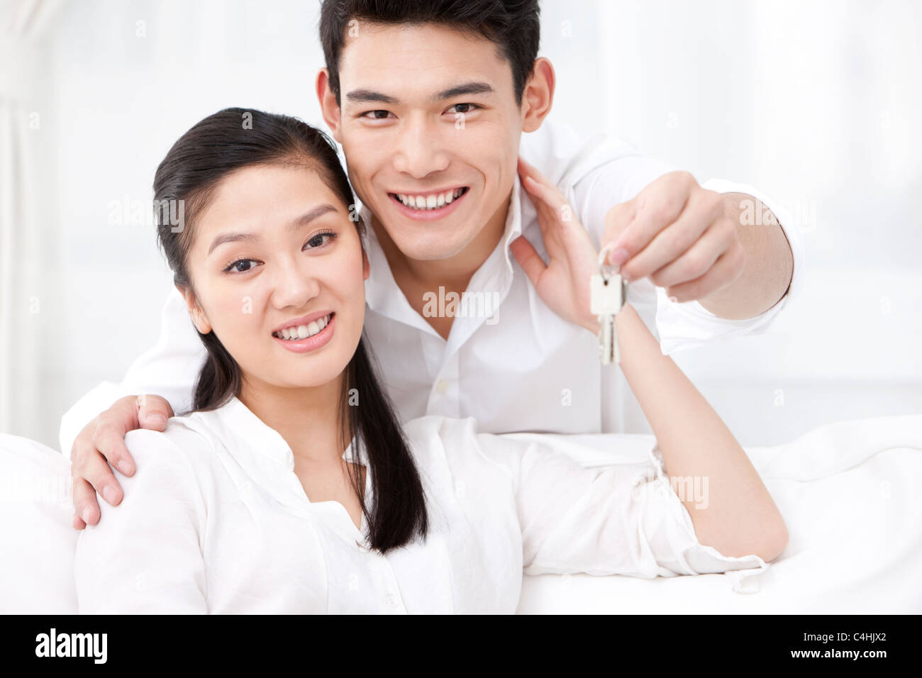 Happy couple holding up keys Stock Photo - Alamy