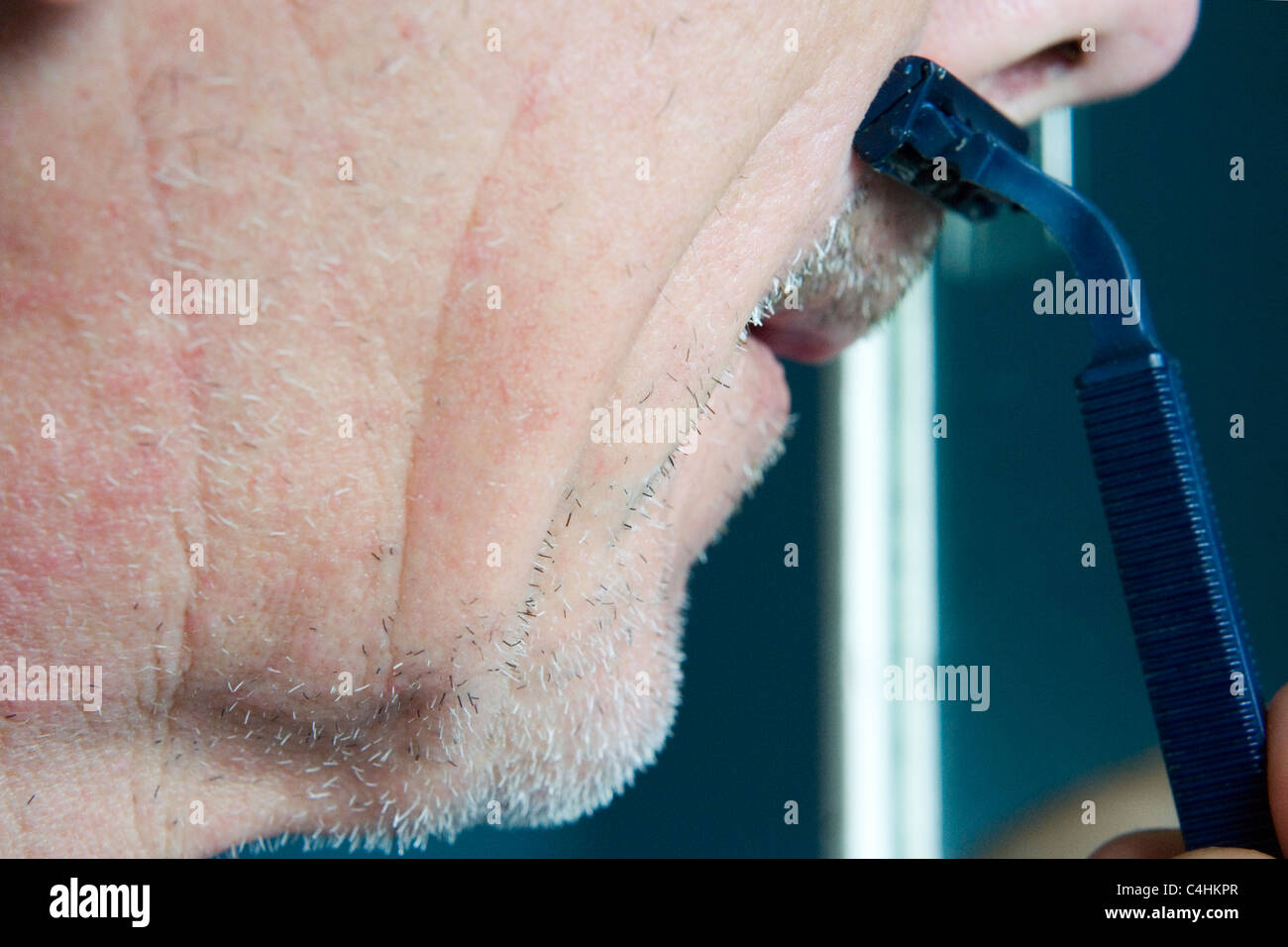 man using a disposable razor to shave heavy stubble Stock Photo - Alamy
