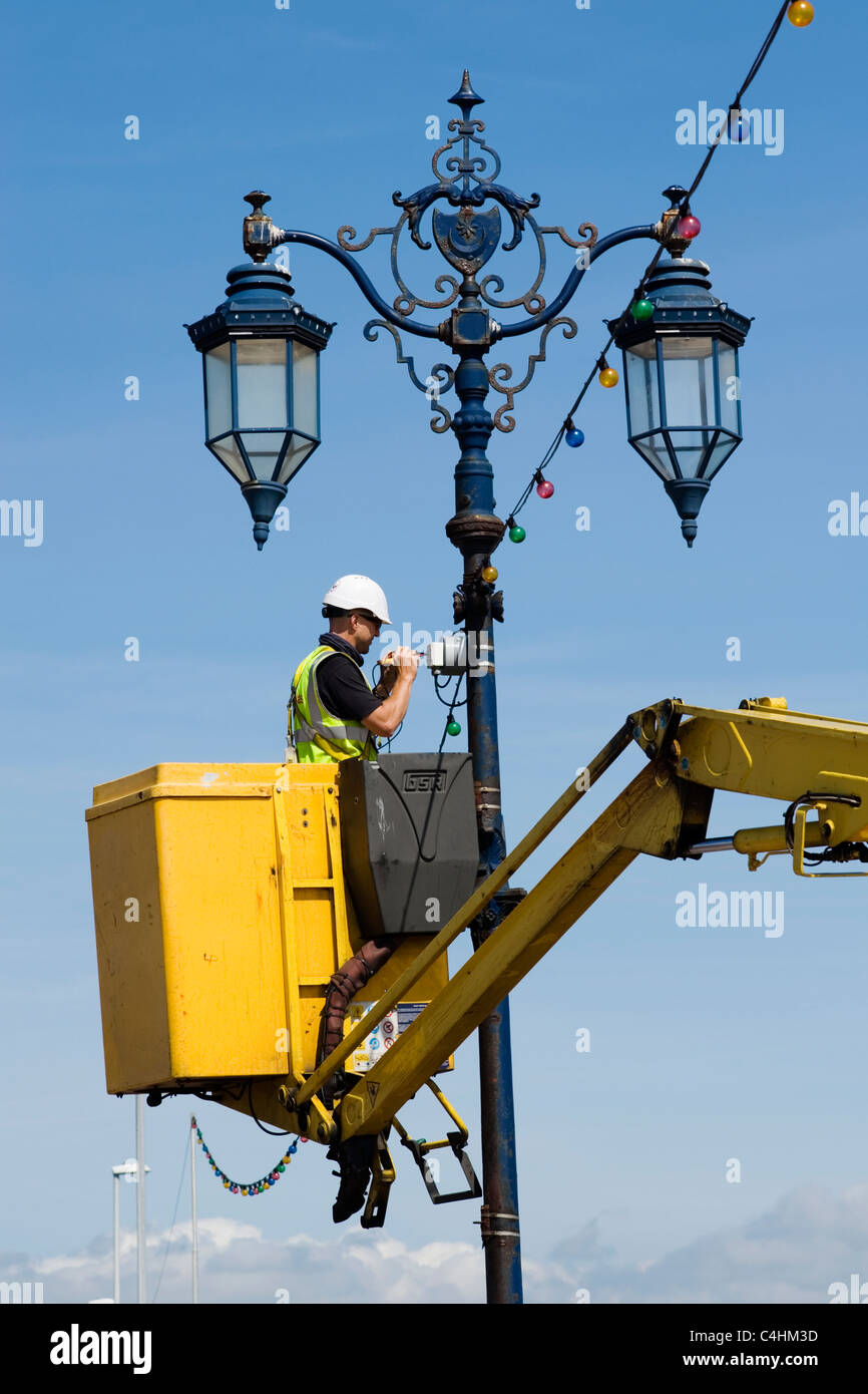 workman carrying out maintenance on a seafront lamp standard Stock ...