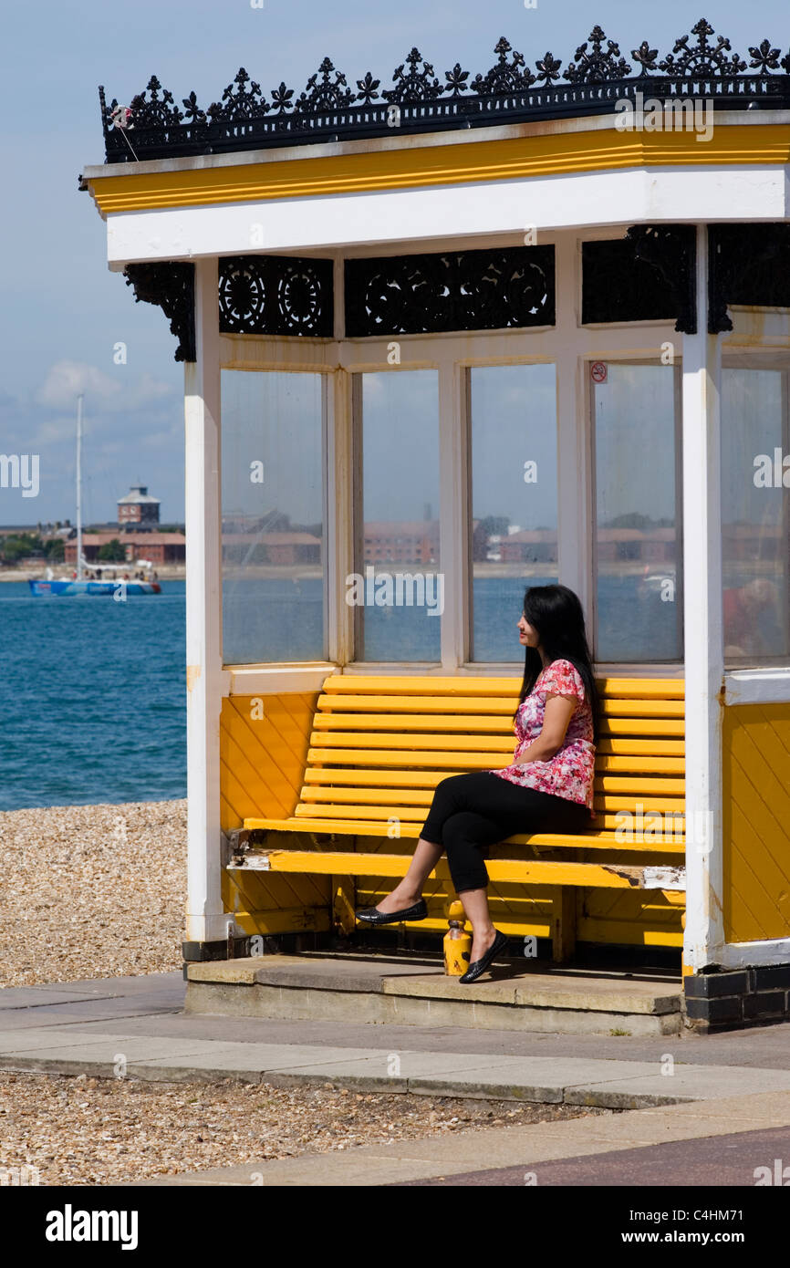young woman relaxing in seafront shelter looking out to sea Stock Photo ...