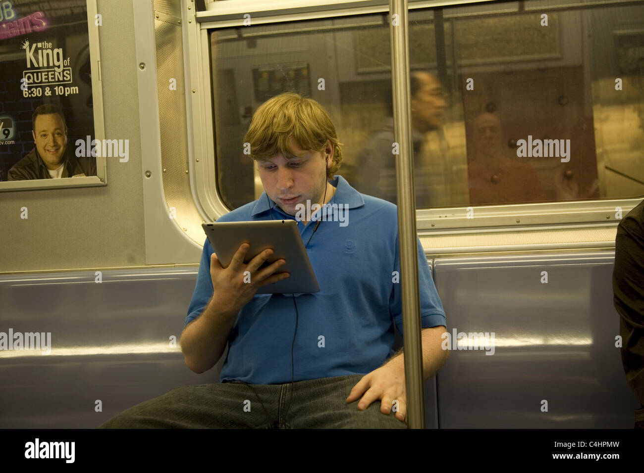 Young man immersed in his ipad screen while plugged into his ipod while ...